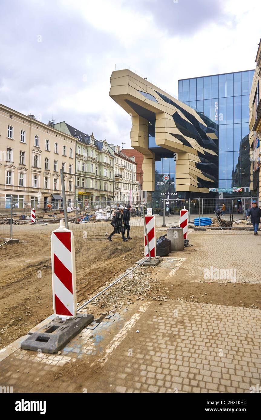 Vertical shot of construction works and walking people close by an ...