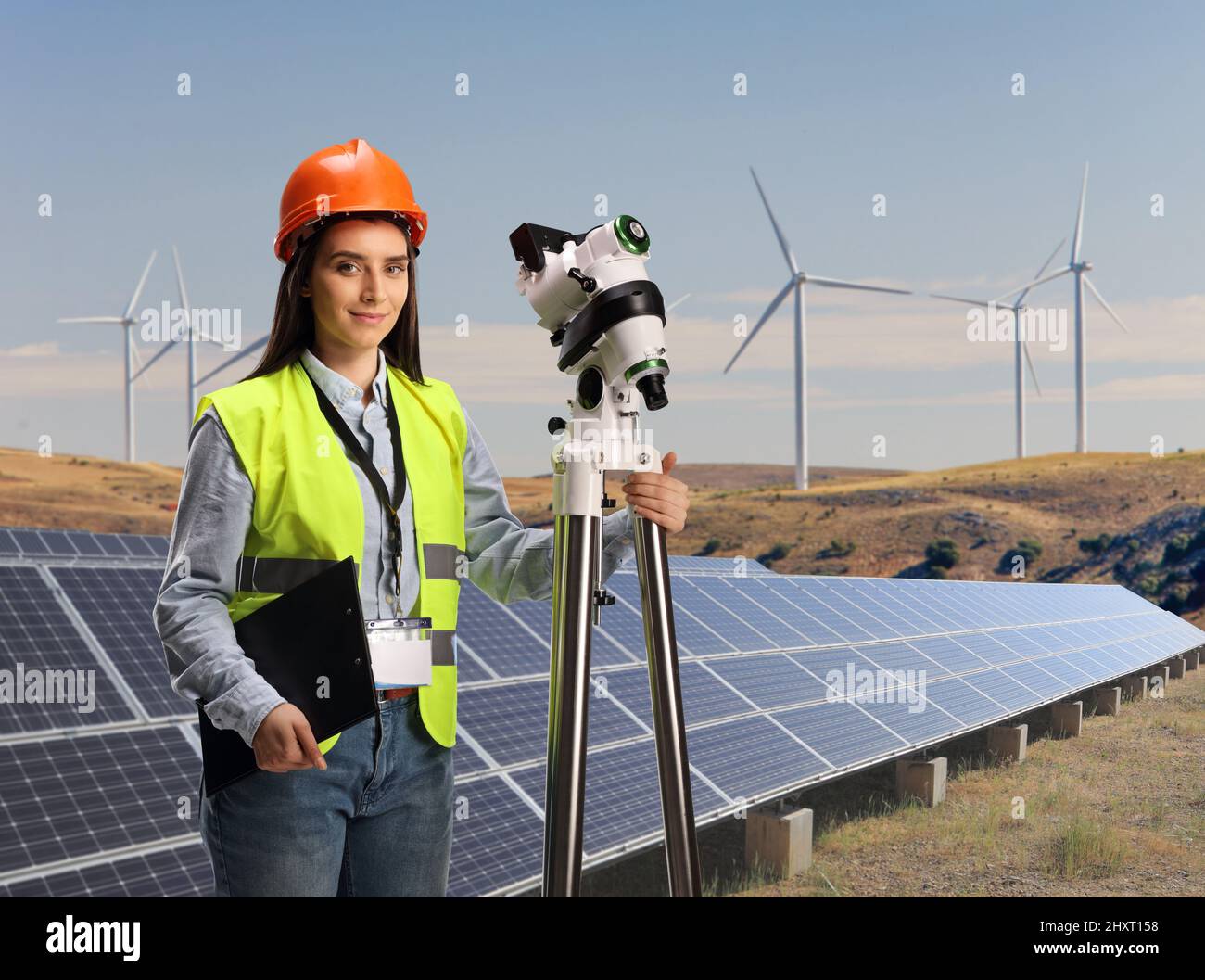 Young female geodetic surveyor with a measuring equipment standing on a ...
