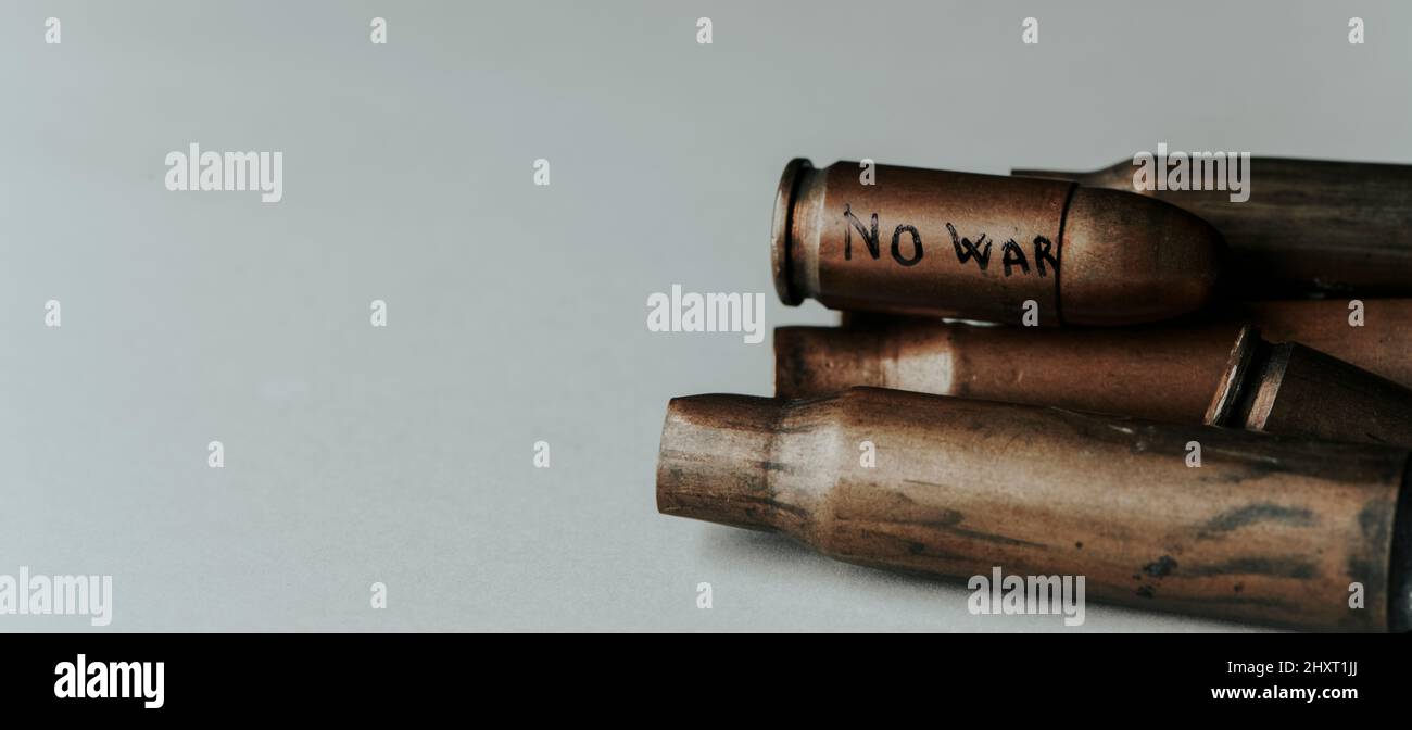 some used bullet shells on a gray background and the text no war ...