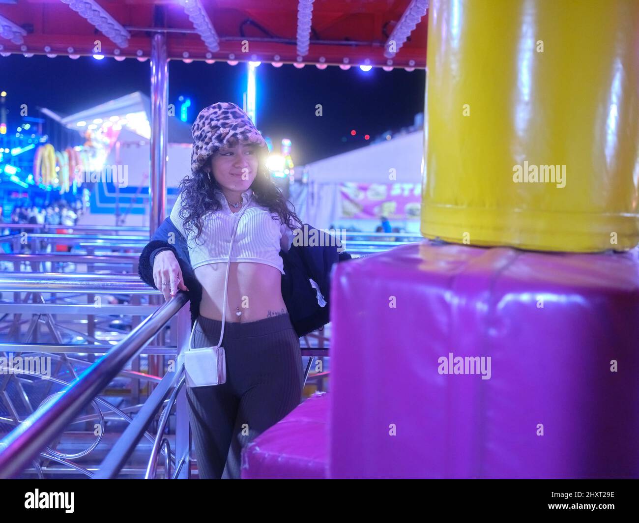 Woman leaning in the railing of an attraction in a night fair Stock ...