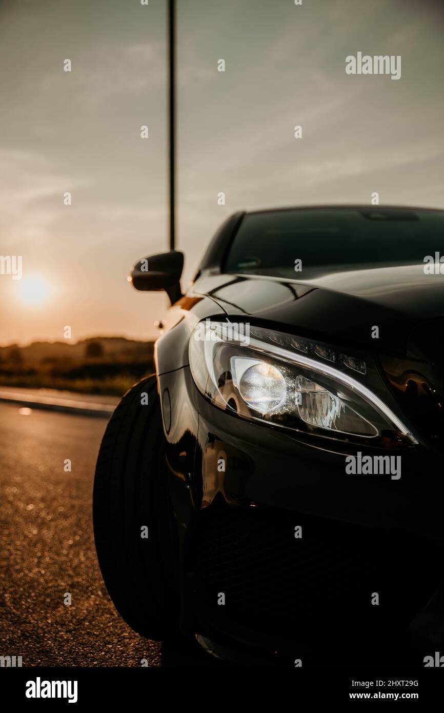 Vertical shot of the front part of a black luxury car at sunset Stock ...