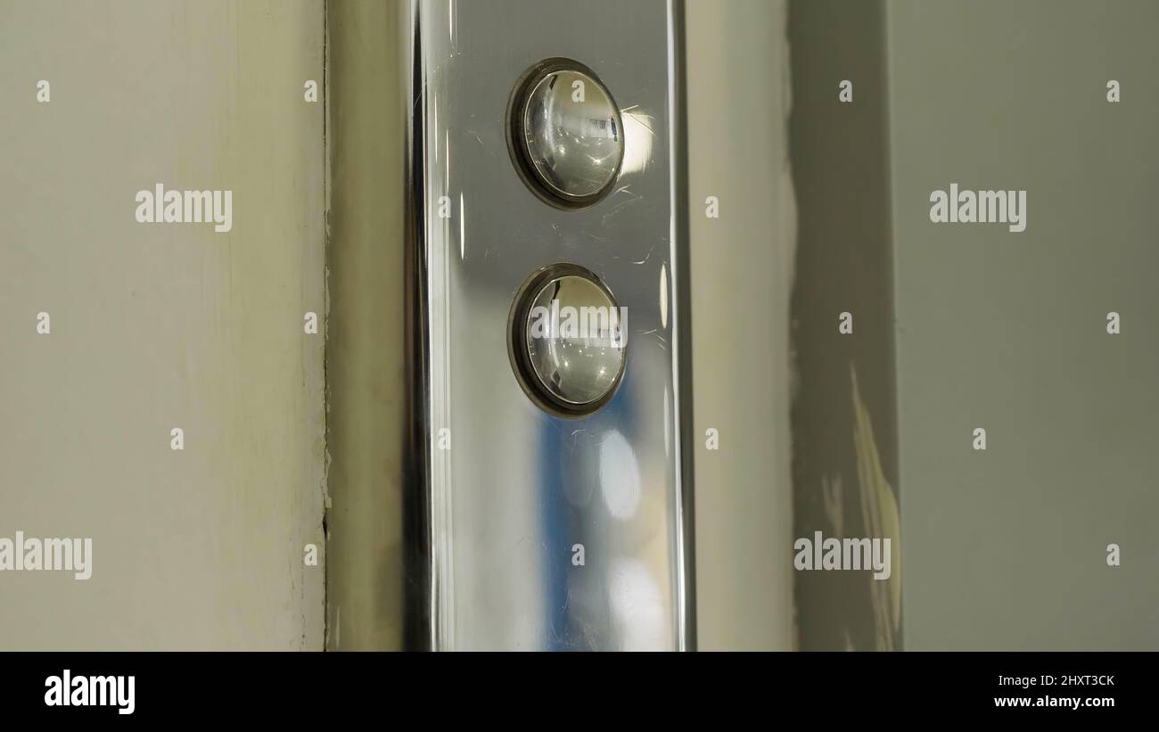 Elevator button and a beige wall. HDR. Close up of metal buttons of a ...