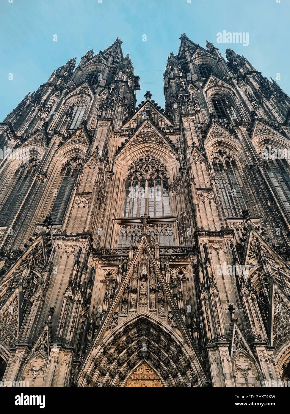 Vertical low angle shot of the Cologne Cathedral facade under the clear ...