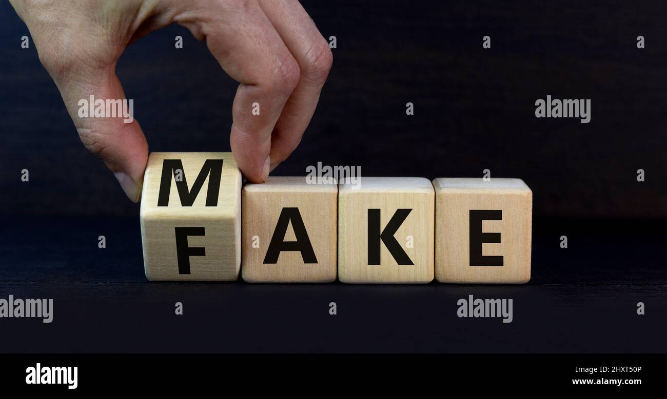 Fake it until you make it symbol. Businessman turns a wooden cube and ...