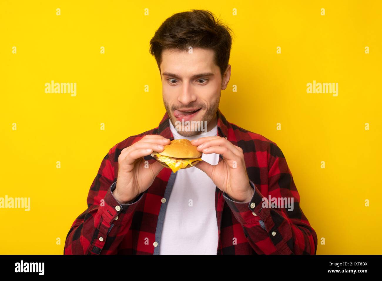 Funny Young Guy Holding Burger At Studio Stock Photo - Alamy