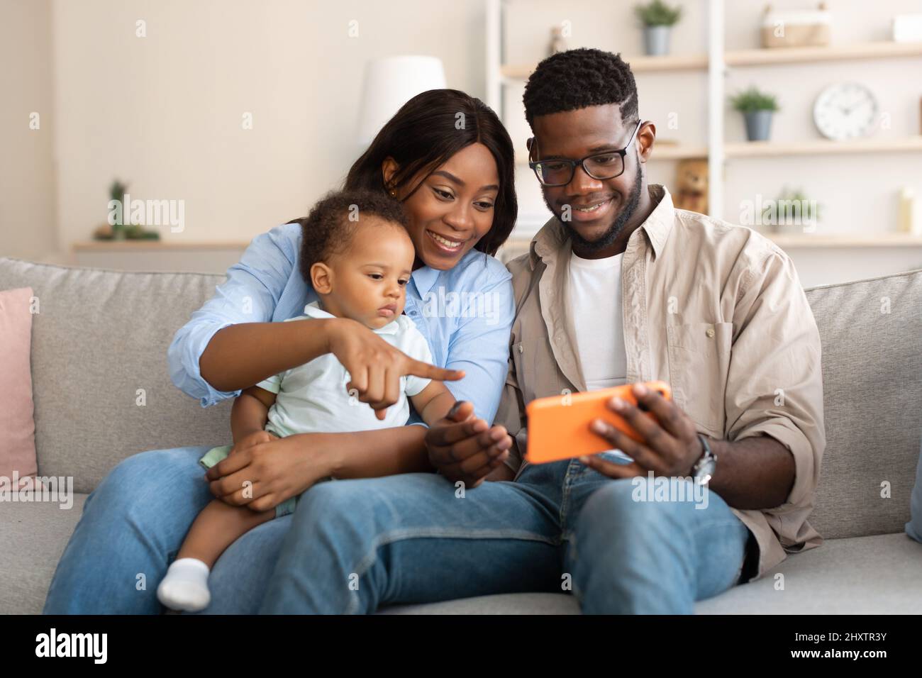 African American family using cellphone with baby at home Stock Photo ...