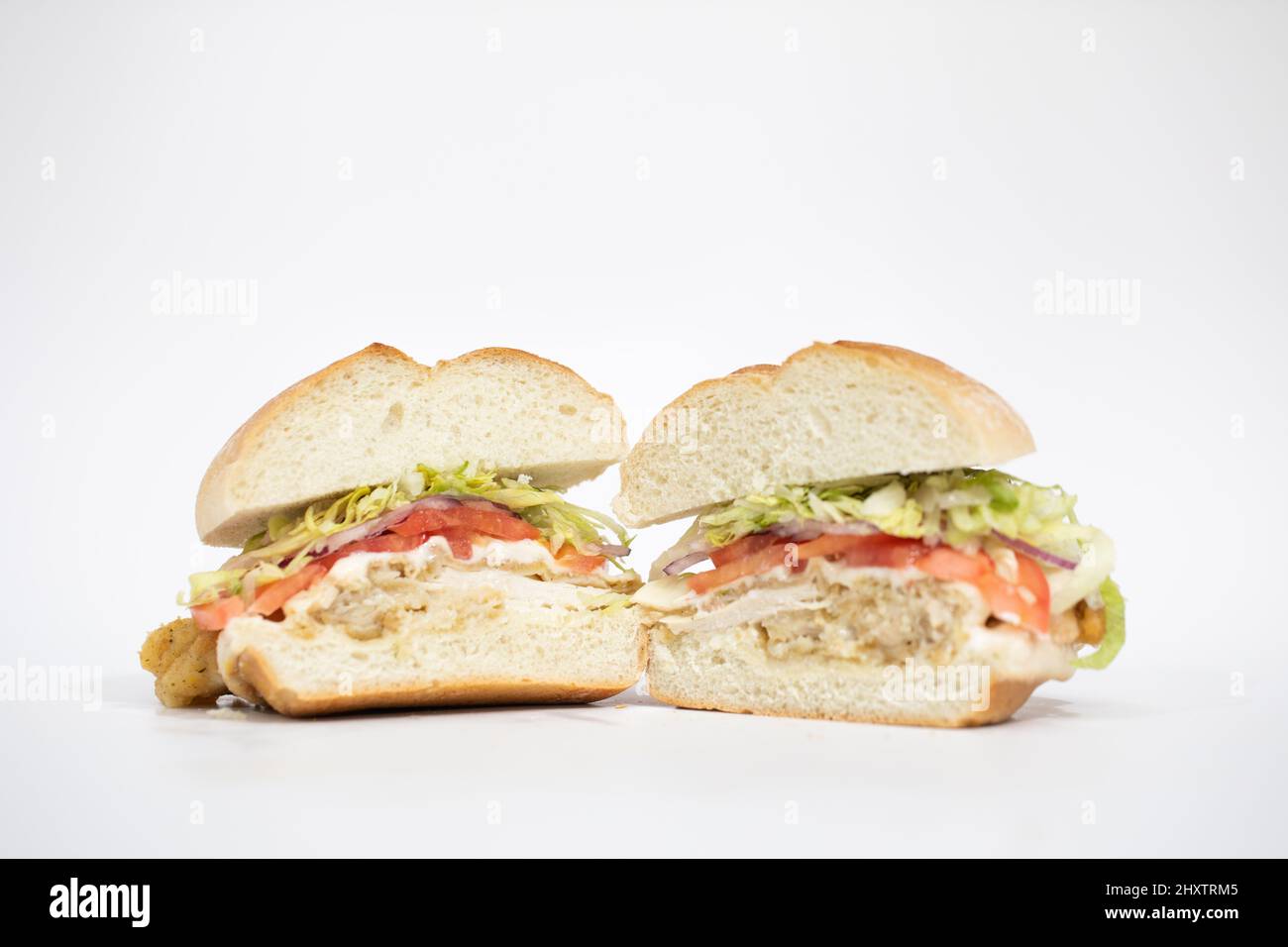 Closeup of a delicious sandwich cut into two pieces isolated on white ...