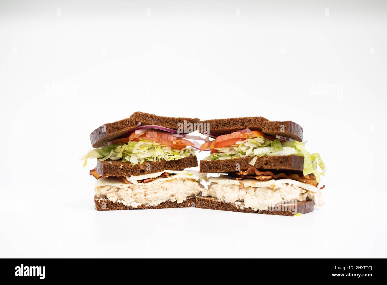 Closeup of a delicious sandwich cut into two pieces isolated on white ...