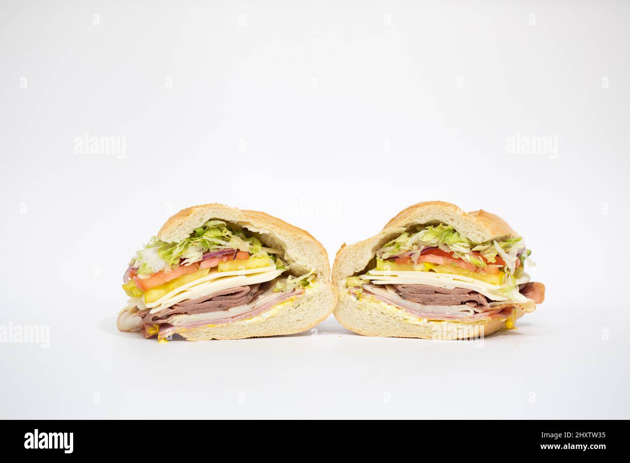 Closeup of a delicious sandwich cut into two pieces isolated on white ...
