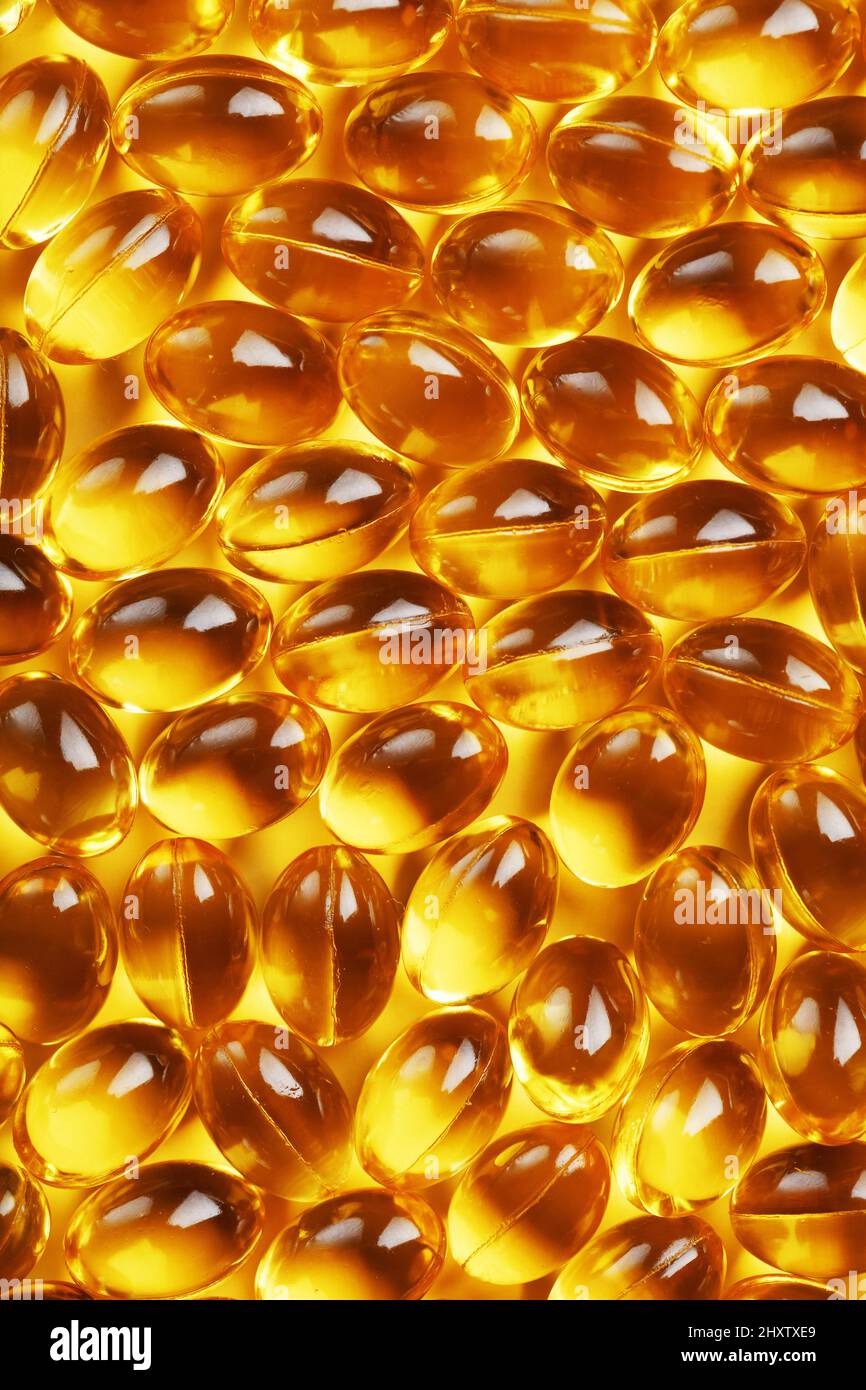 Golden capsules of Vitamin Omega 3 Fish Oil close-up in full screen ...