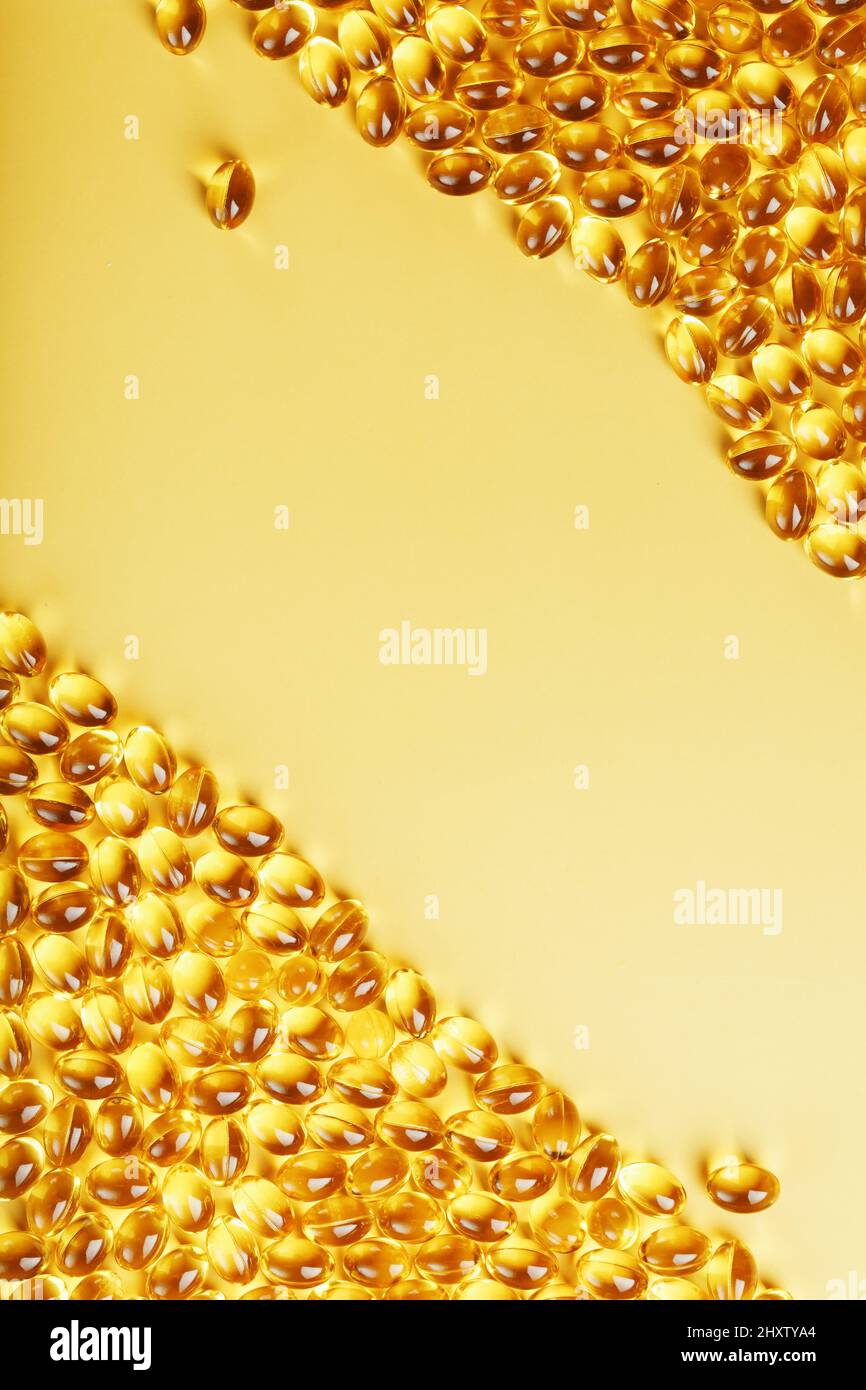 Capsules in a shell with liquid vitamin D3 on a yellow background and a ...