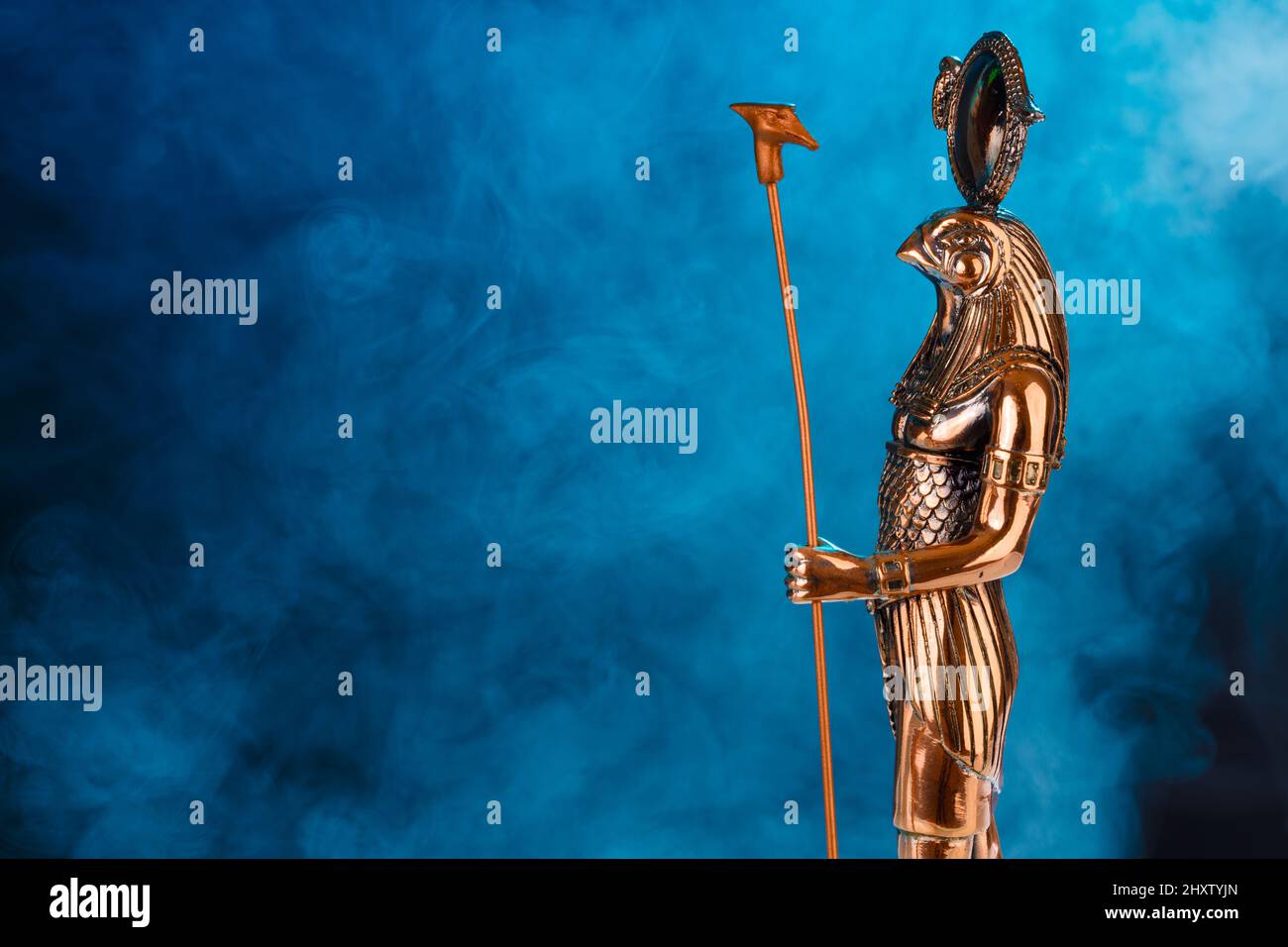 gold Egyptian figurine of the god RA with the head of a falcon in blue ...