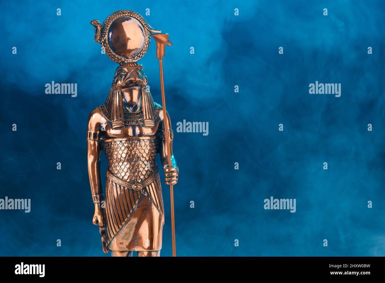 gold Egyptian figurine of the god RA with the head of a falcon in blue ...