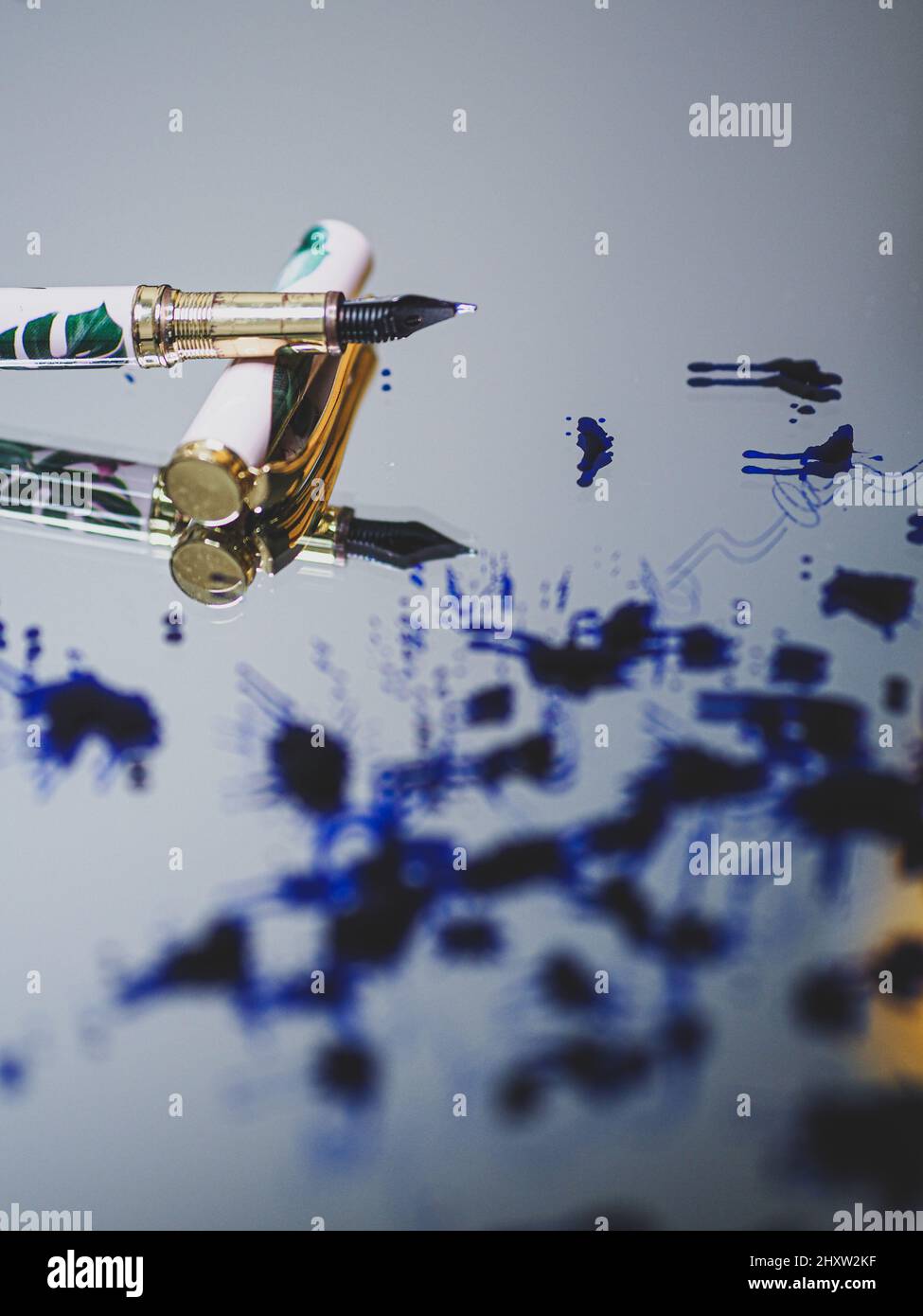 Vertical selective focus shot of a pen put on its cover and its blue ...