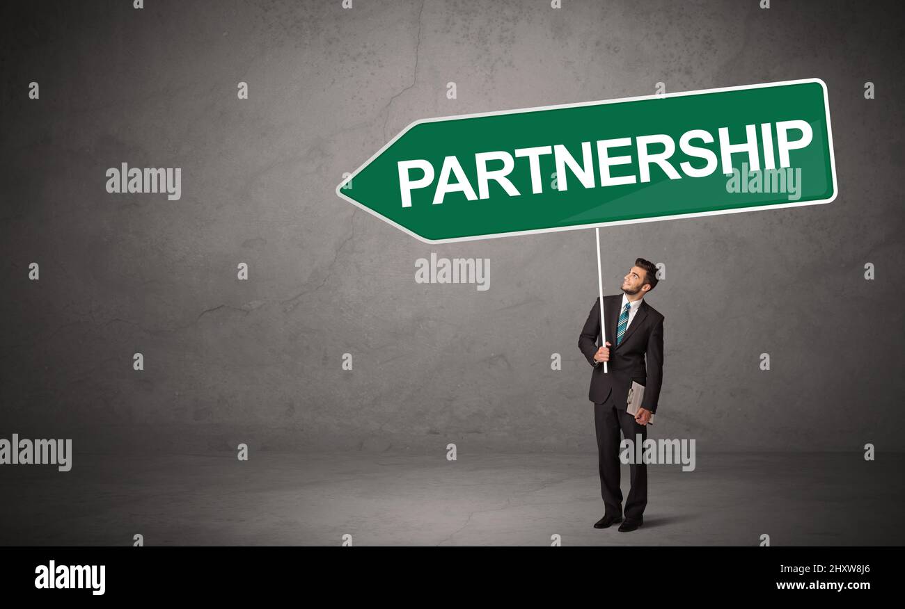 Young business person in casual holding road sign Stock Photo - Alamy