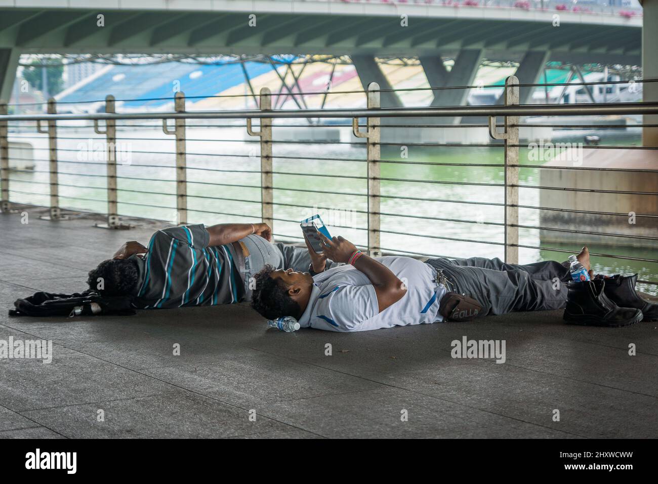 People laying on a bridge over a river in Singapore Stock Photo - Alamy