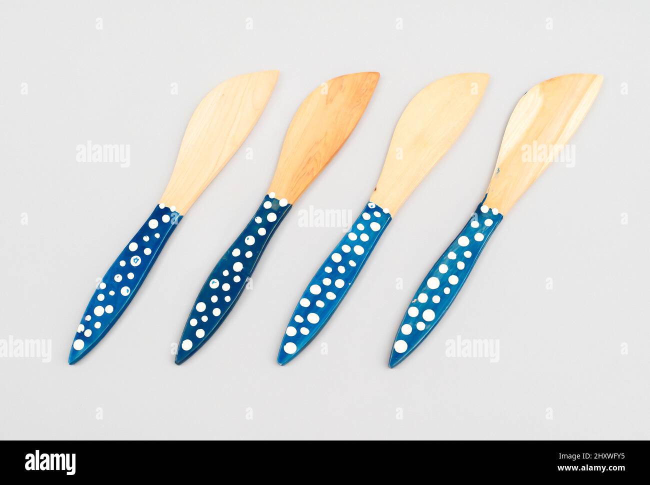 Top view of 4 wooden butter knives with blue handles with white dots ...