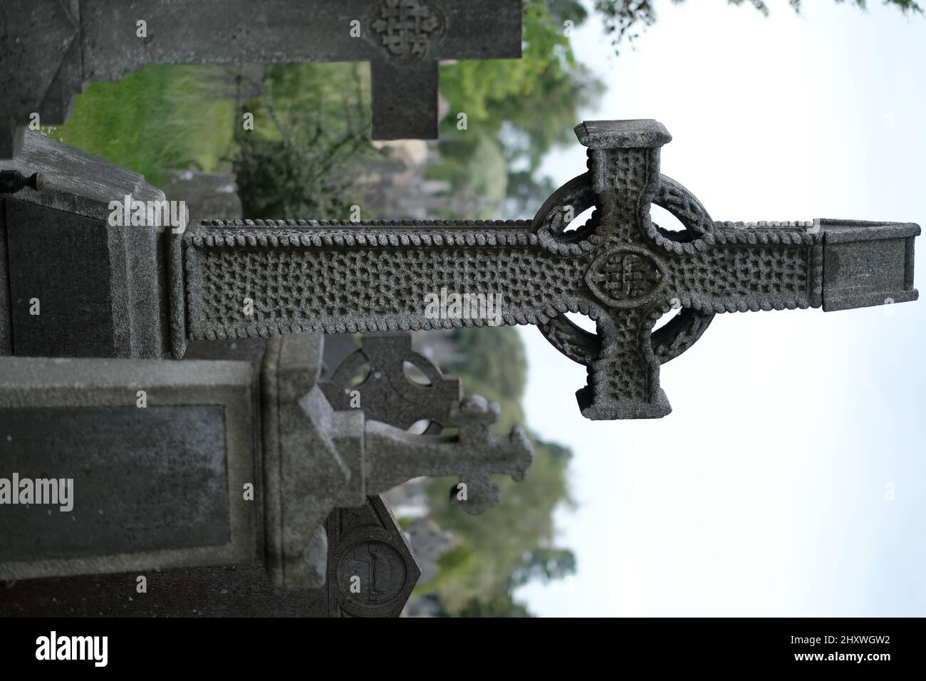 Vertical shallow focus of a large carved stone cross with a background ...