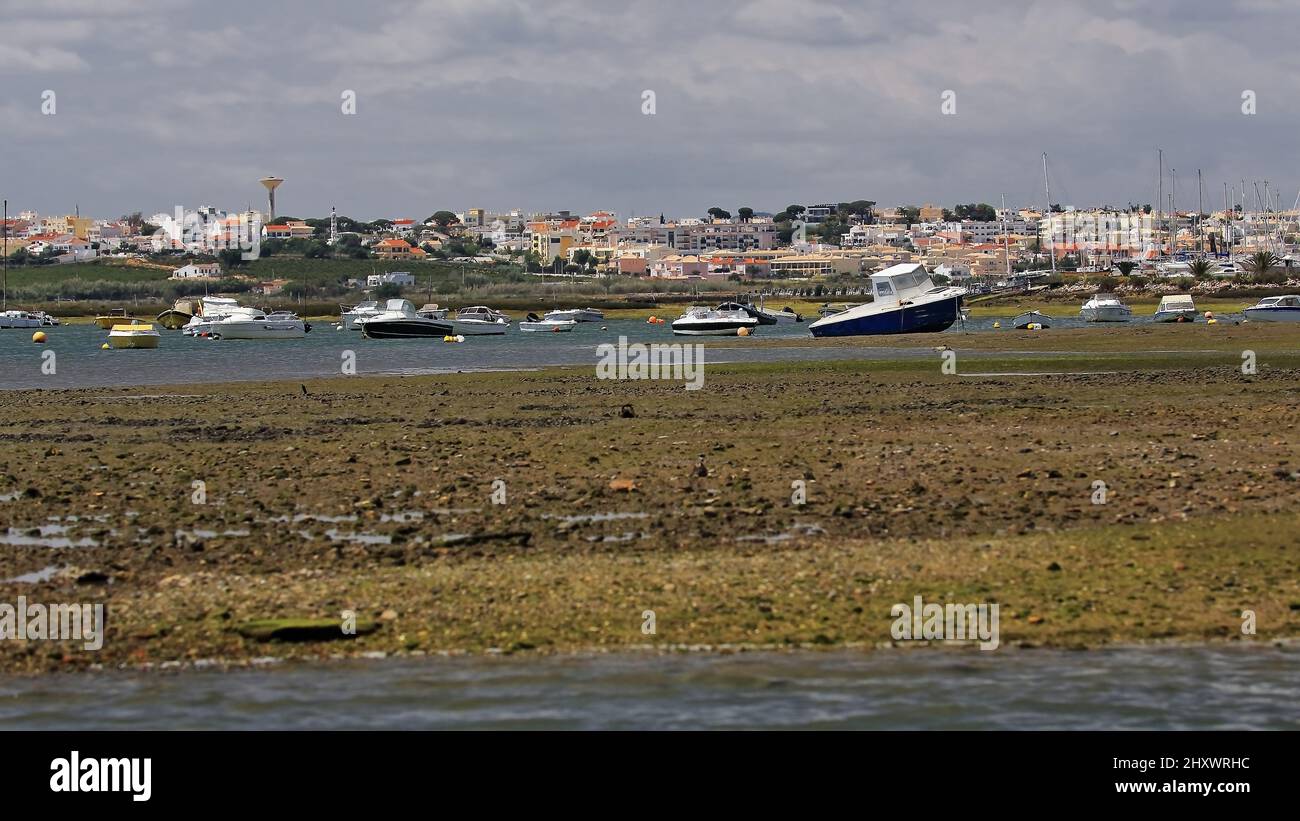 Anchored and grounded boats among the mudflats-Ria Formosa lagoon. Faro ...