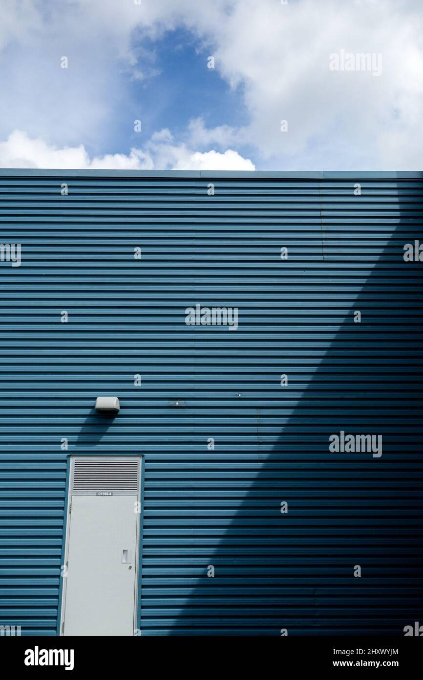 Vertical shot of the facade of a dark blue building with white door and ...