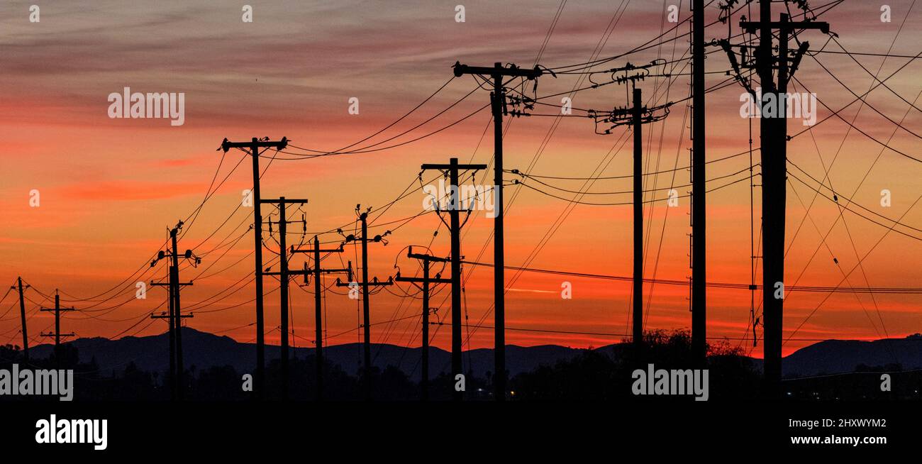 Silhouette view of the electric power poles and wires against dusk sky ...