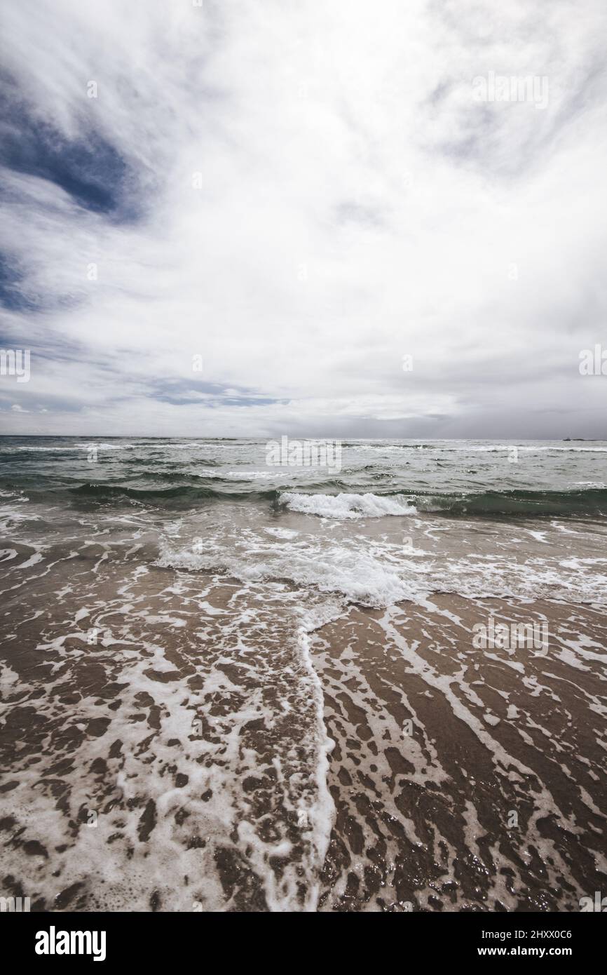 View of a sea waves making foam and mixing with the sky Stock Photo - Alamy