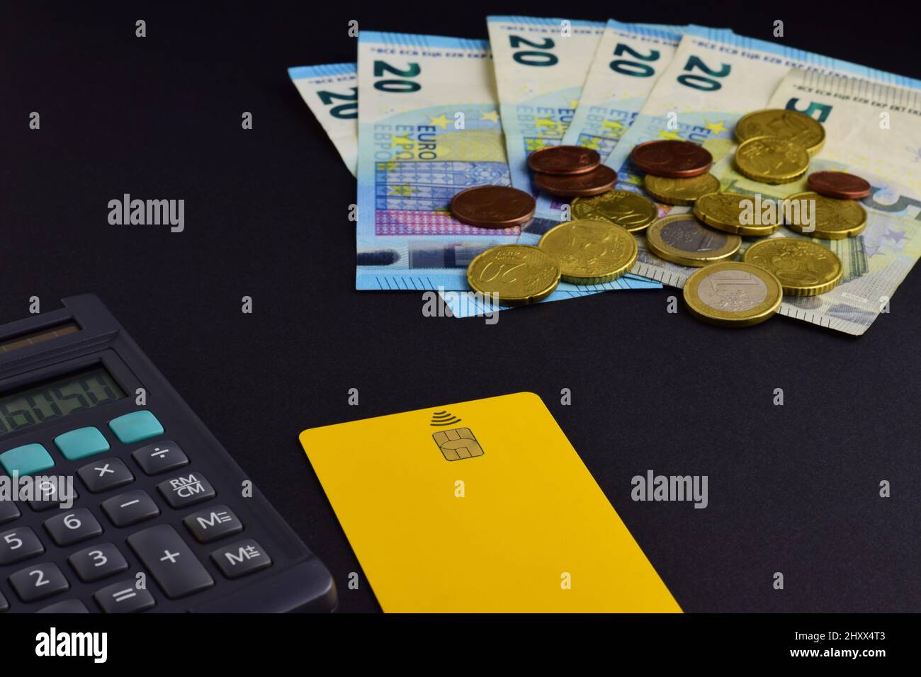 Calculator, a yellow credit card and money on a dark background Stock ...