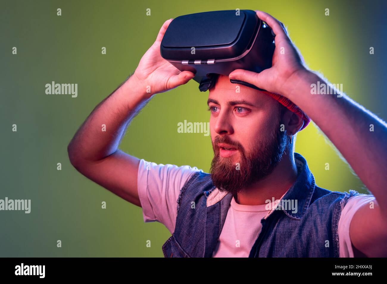 Portrait of serious gamer hipster man takes off vr headset, playing ...