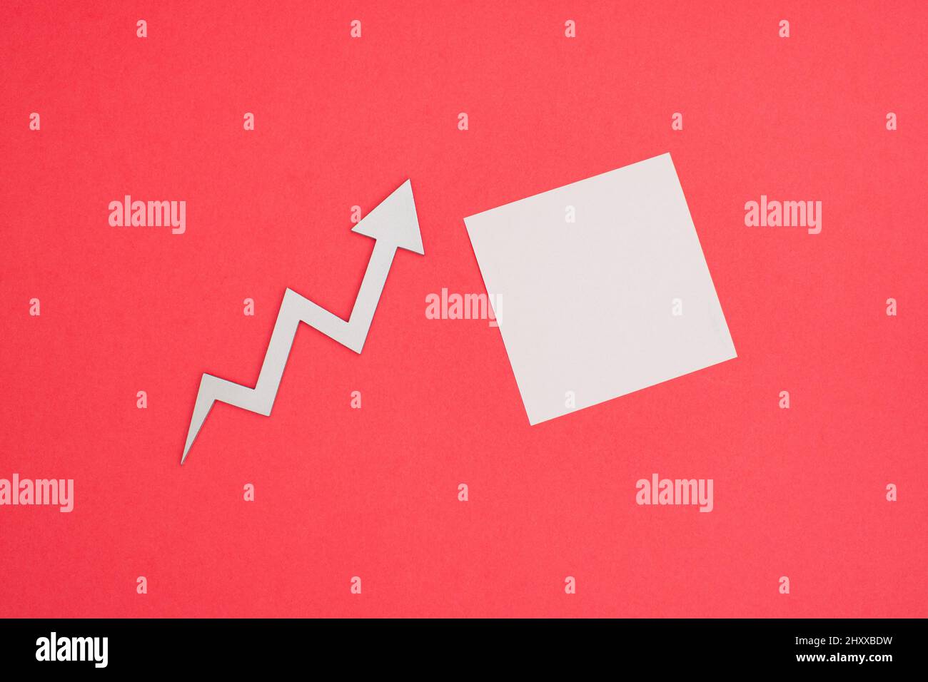 Arrow and sheet of paper with copy space isolated on red background ...