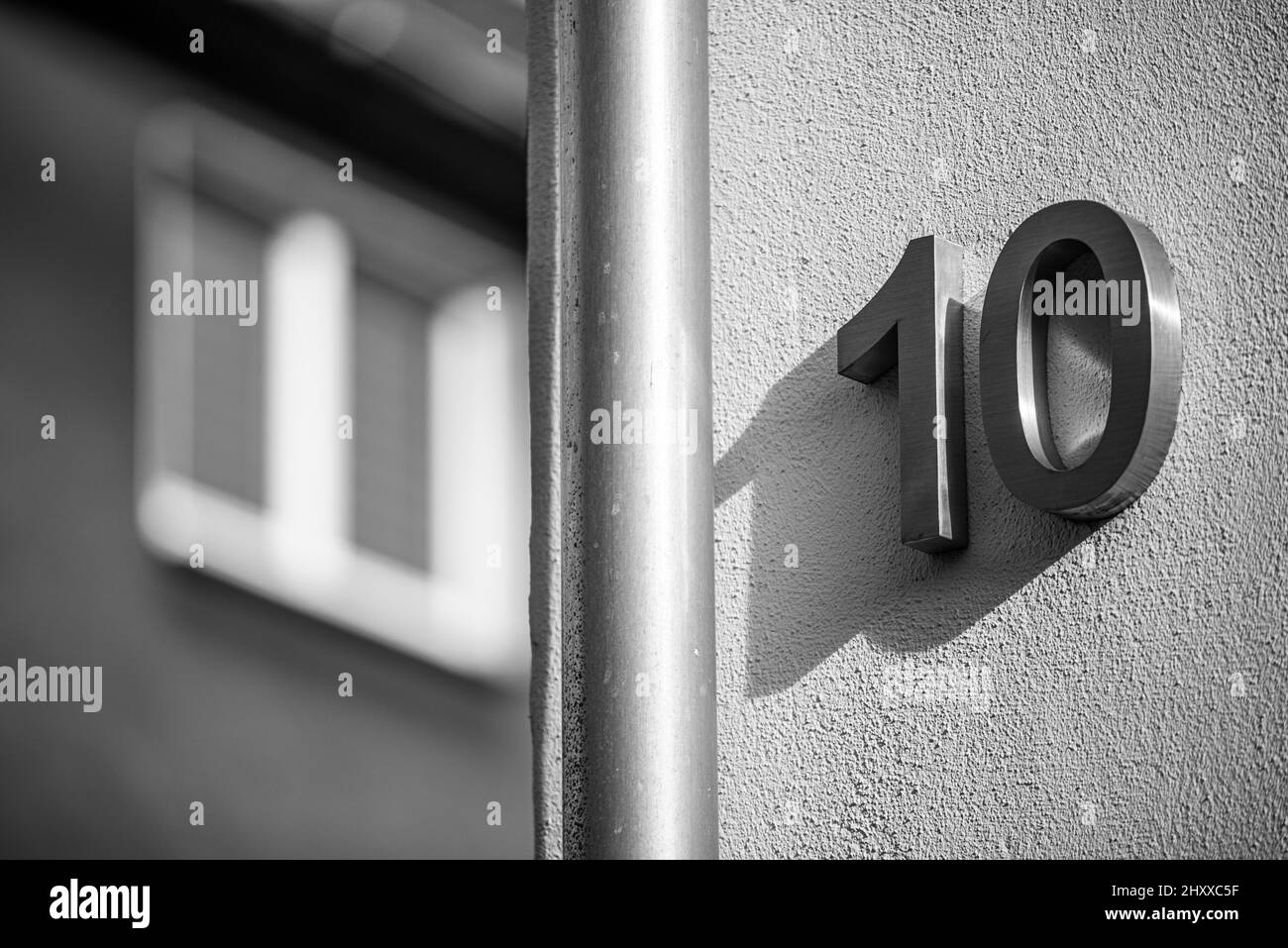 Grayscale of a house number "10" attached to a wall Stock Photo - Alamy