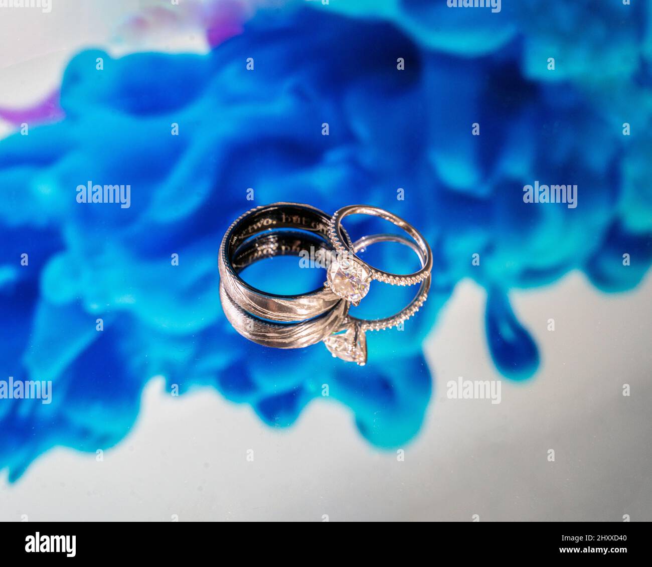 Closeup of wedding rings on a mirror with a blue smoke background Stock ...