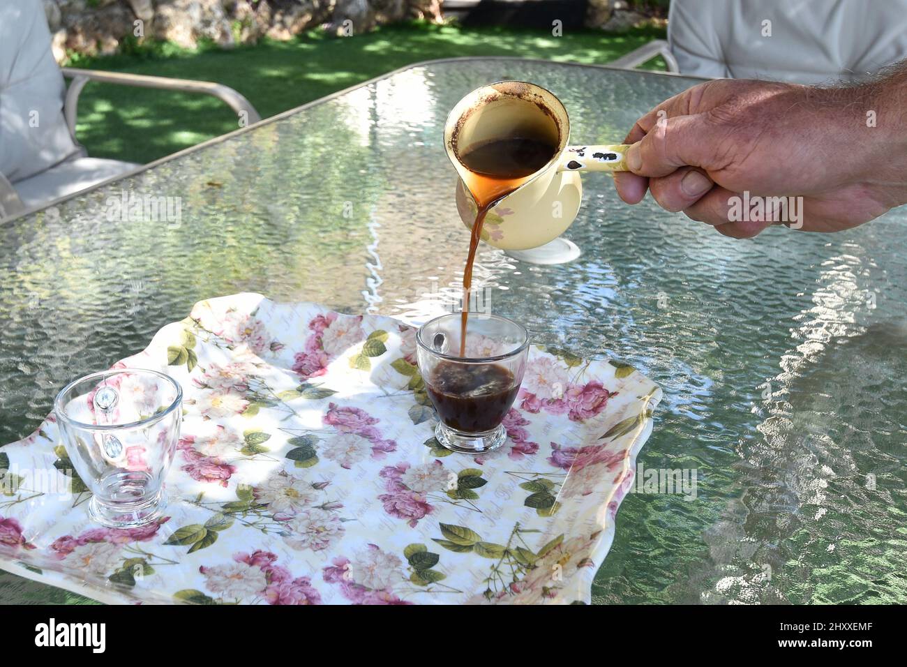 View of pouring traditional Druze black coffee from a jazzve into ...