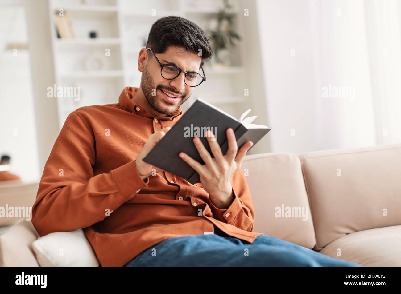 Young Arab man in glasses reading book Stock Photo - Alamy