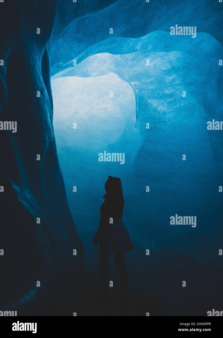 Vertical shot of a female silhouette standing in the Swiss Alps ice ...