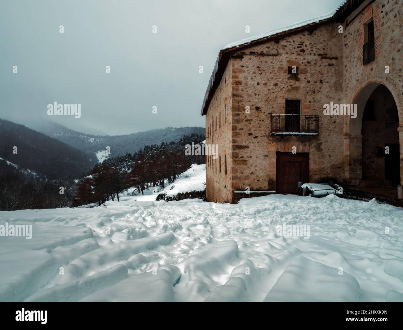 Stone building with a snowy area surrounded by dense mountains in ...