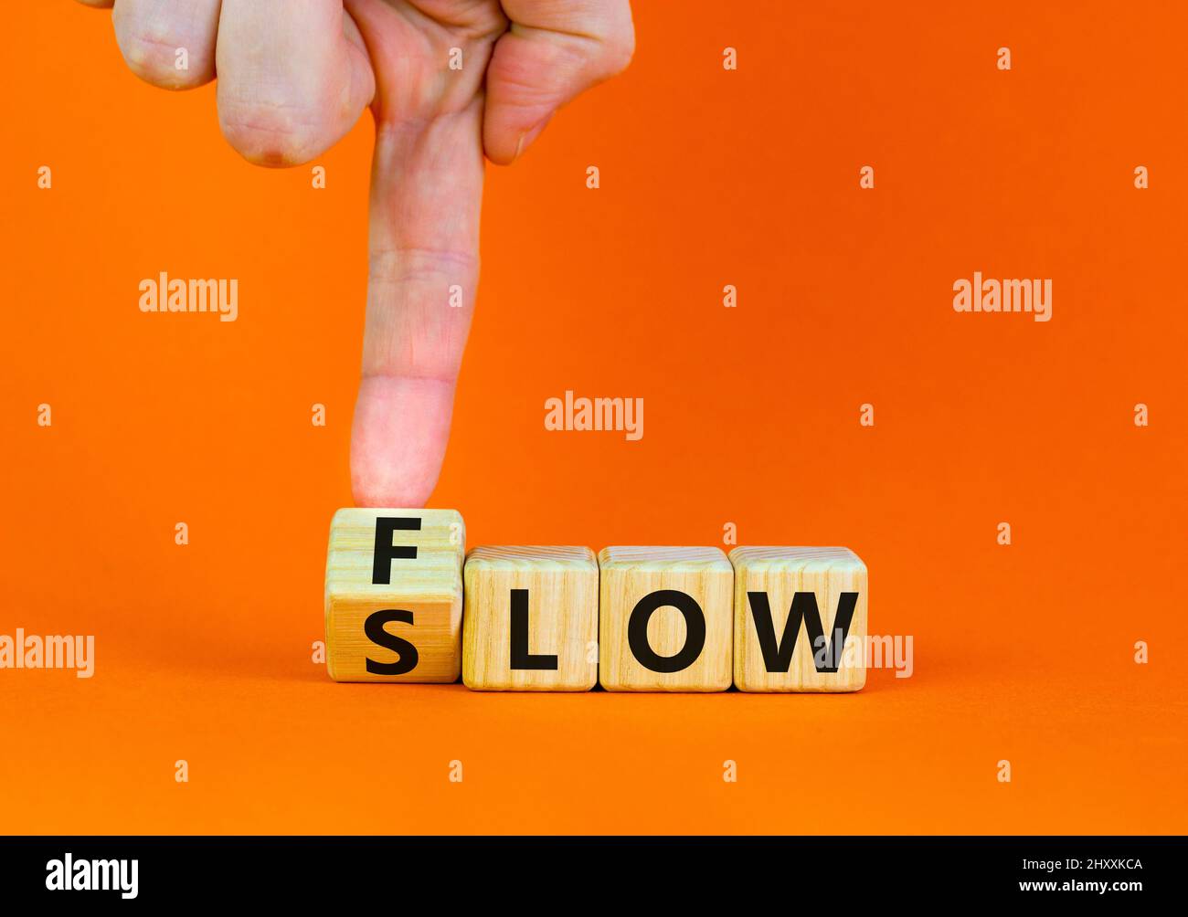 Be slow or in the flow symbol. Businessman turns a wooden cube and ...