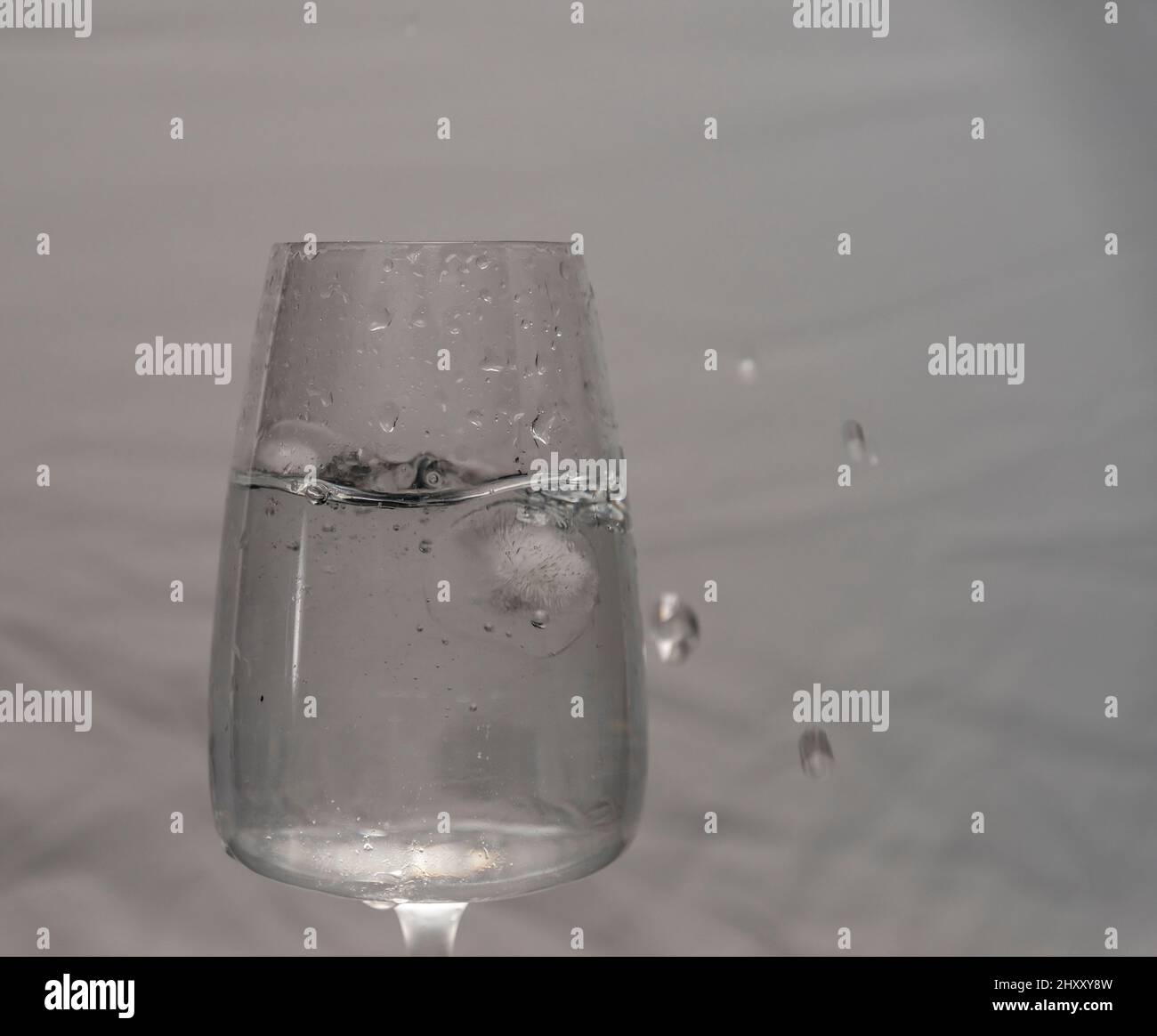 Glass with running clean water and gray dark background Stock Photo - Alamy