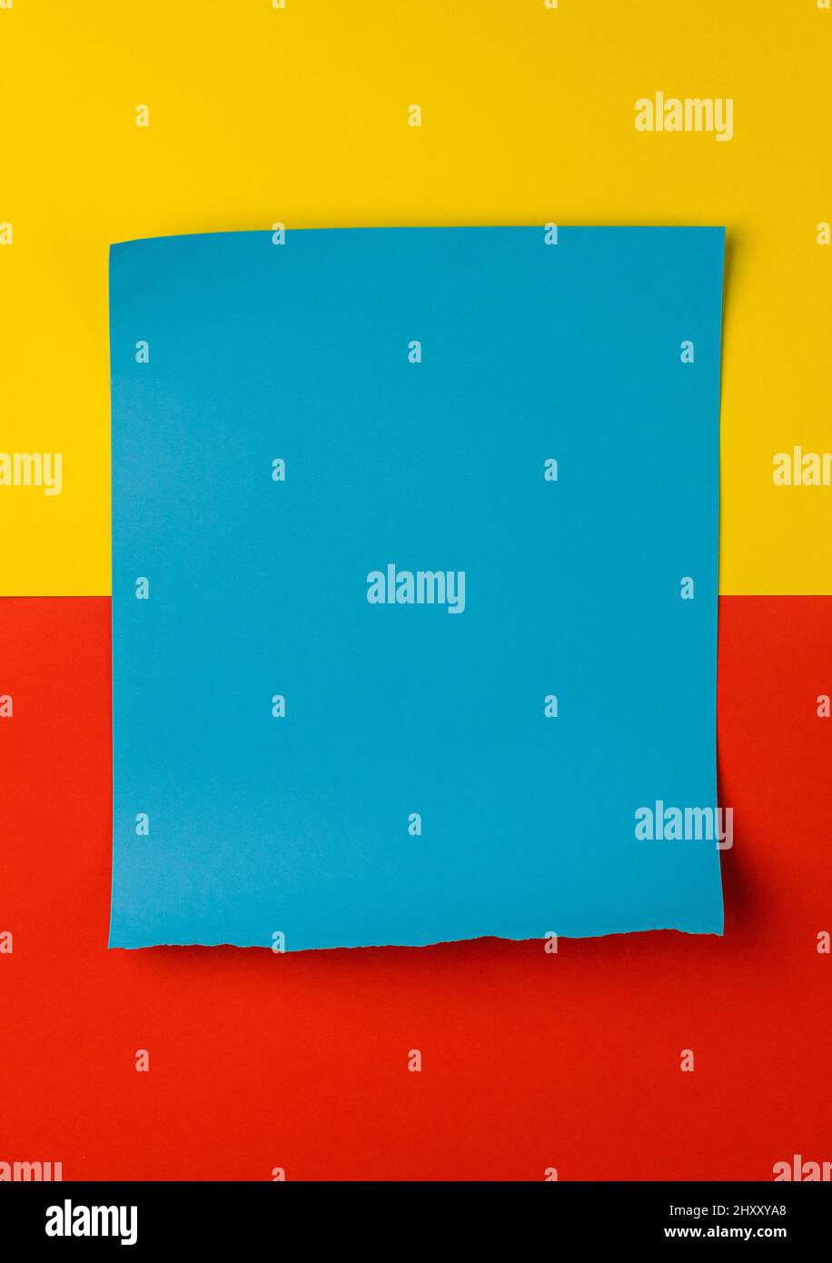 Blue sheet of paper with copy space isolated on bright yellow-red ...