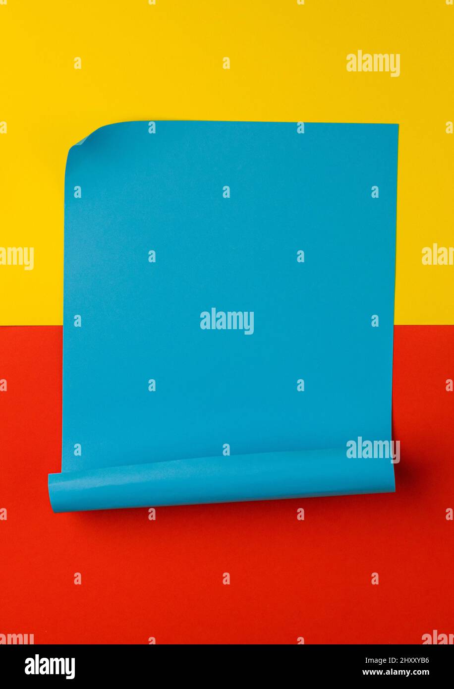 Blue sheet of paper with copy space isolated on bright yellow-red ...