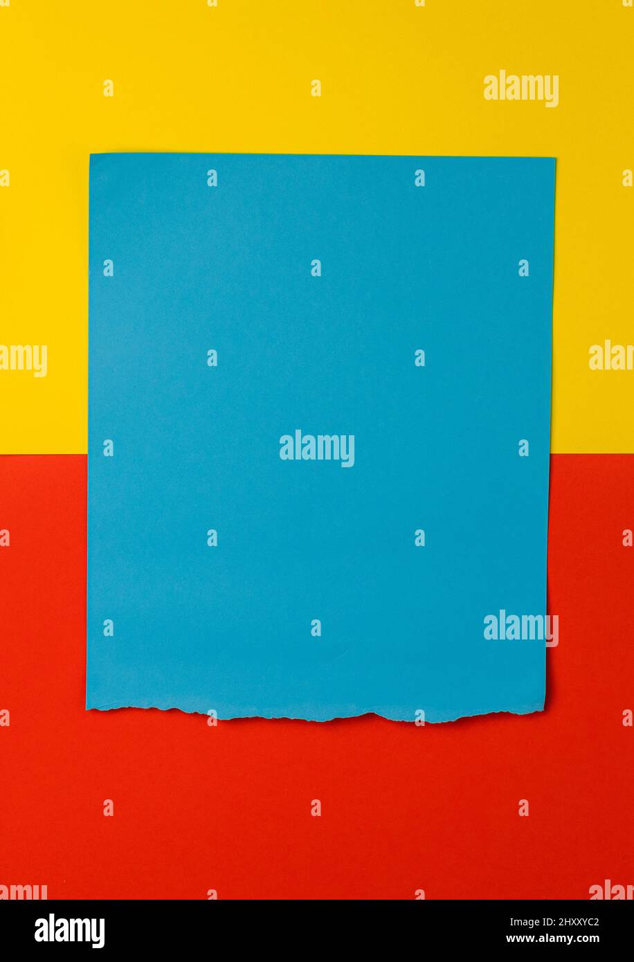 Blue sheet of paper with copy space isolated on bright yellow-red ...