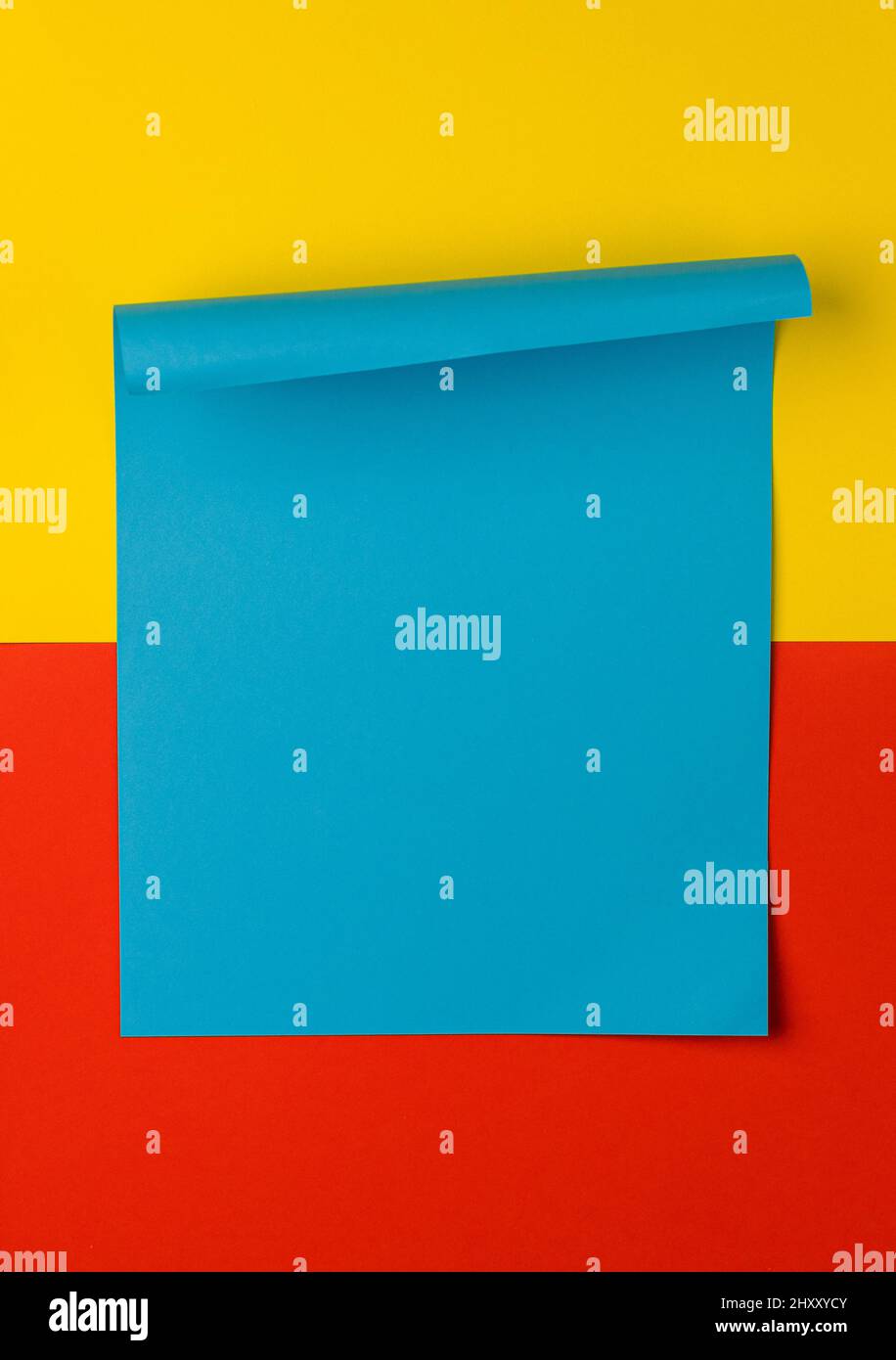 Blue sheet of paper with copy space isolated on bright yellow-red ...