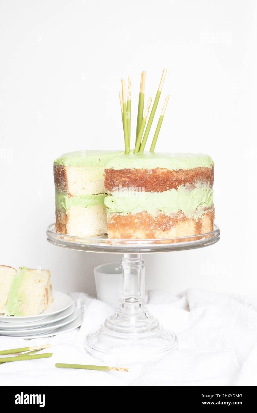 Sliced matcha pocky stick cake with plates isolated on a white ...