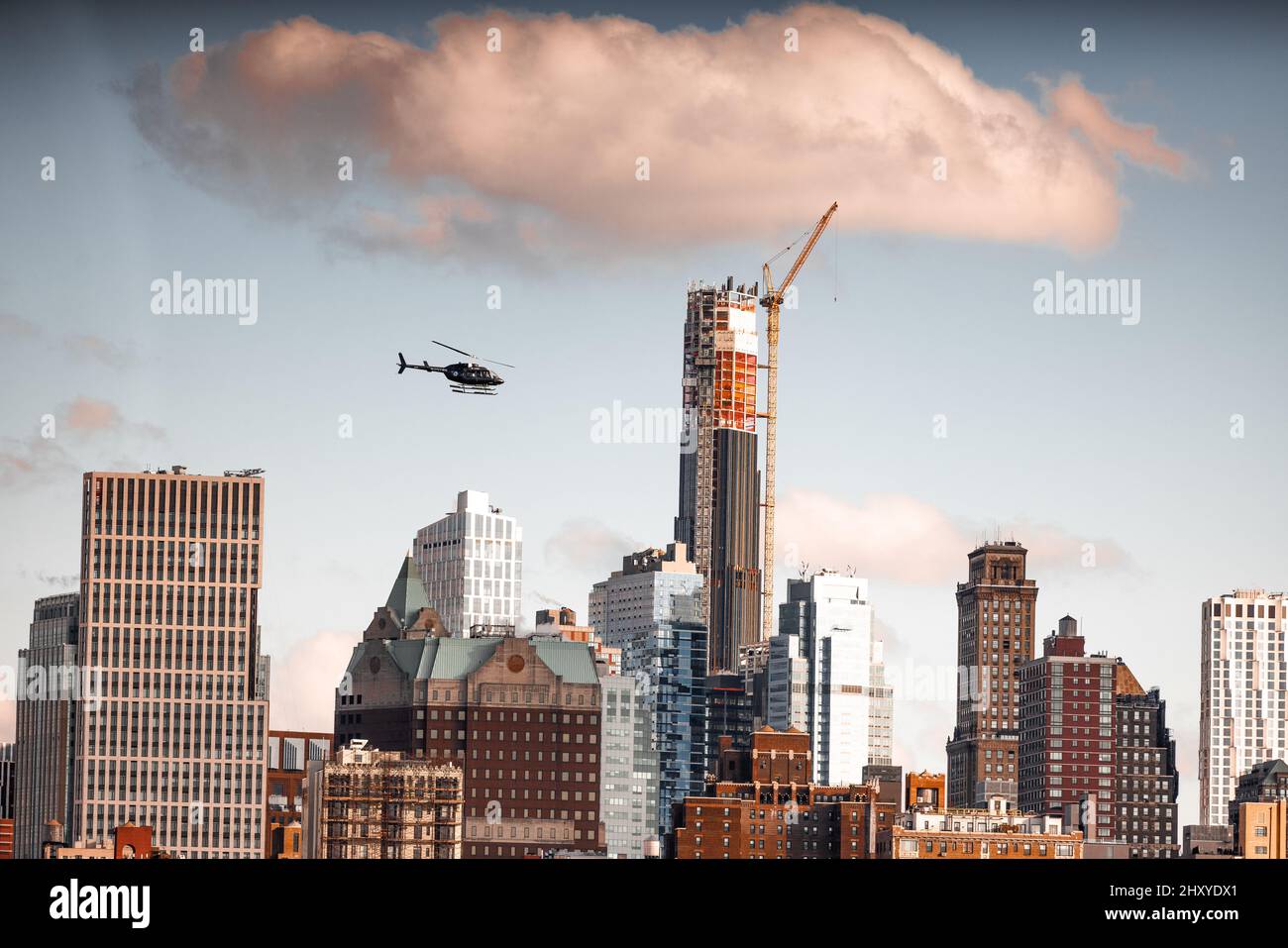 Helicopter flying above skyscrapers on a cloudy sky background Stock ...