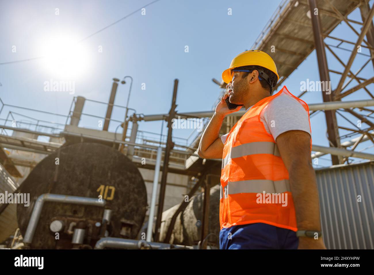 Worker with safety equipment working at construction plant Stock Photo ...