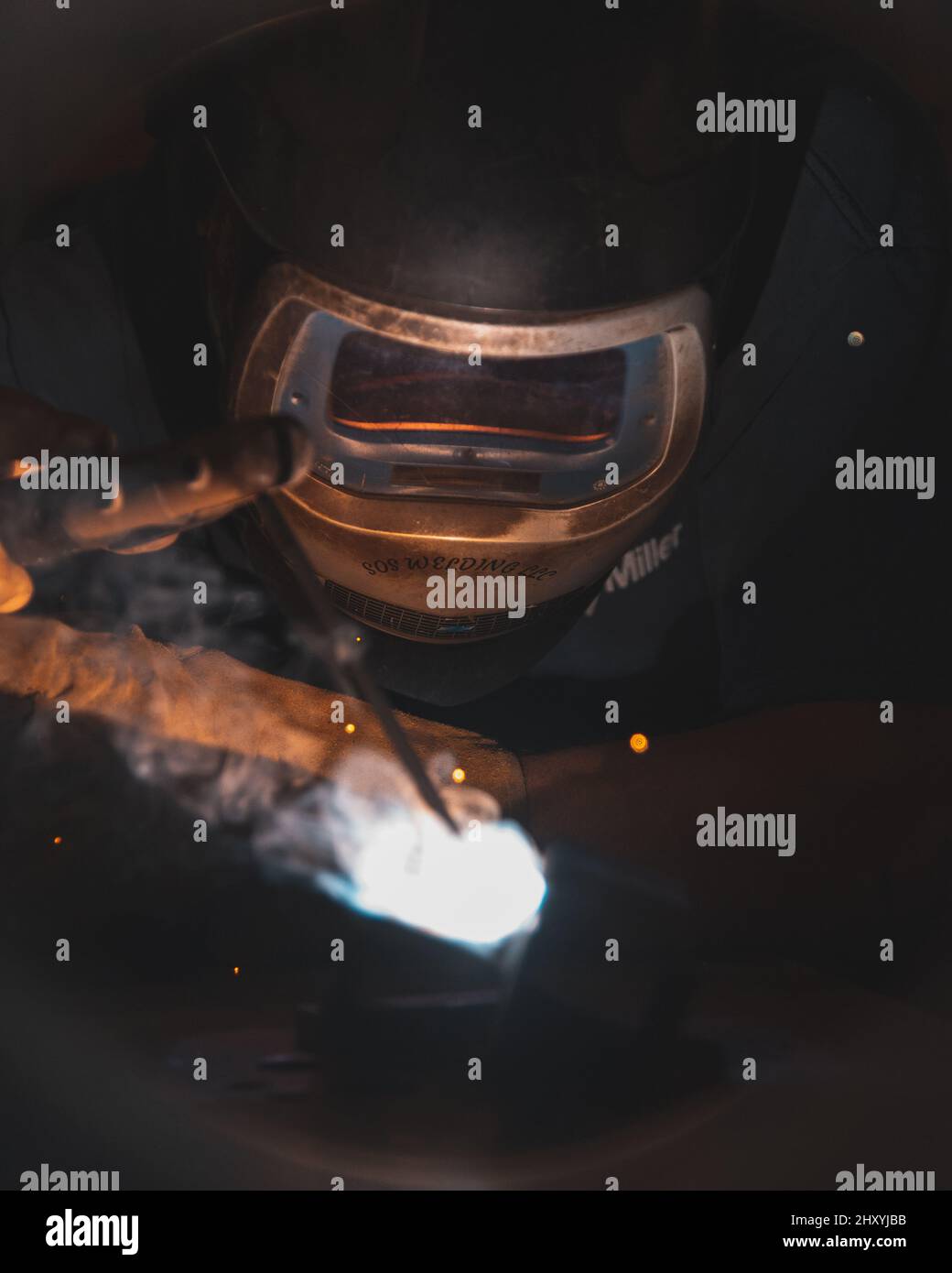 Selective of a man welding metal piece Stock Photo - Alamy