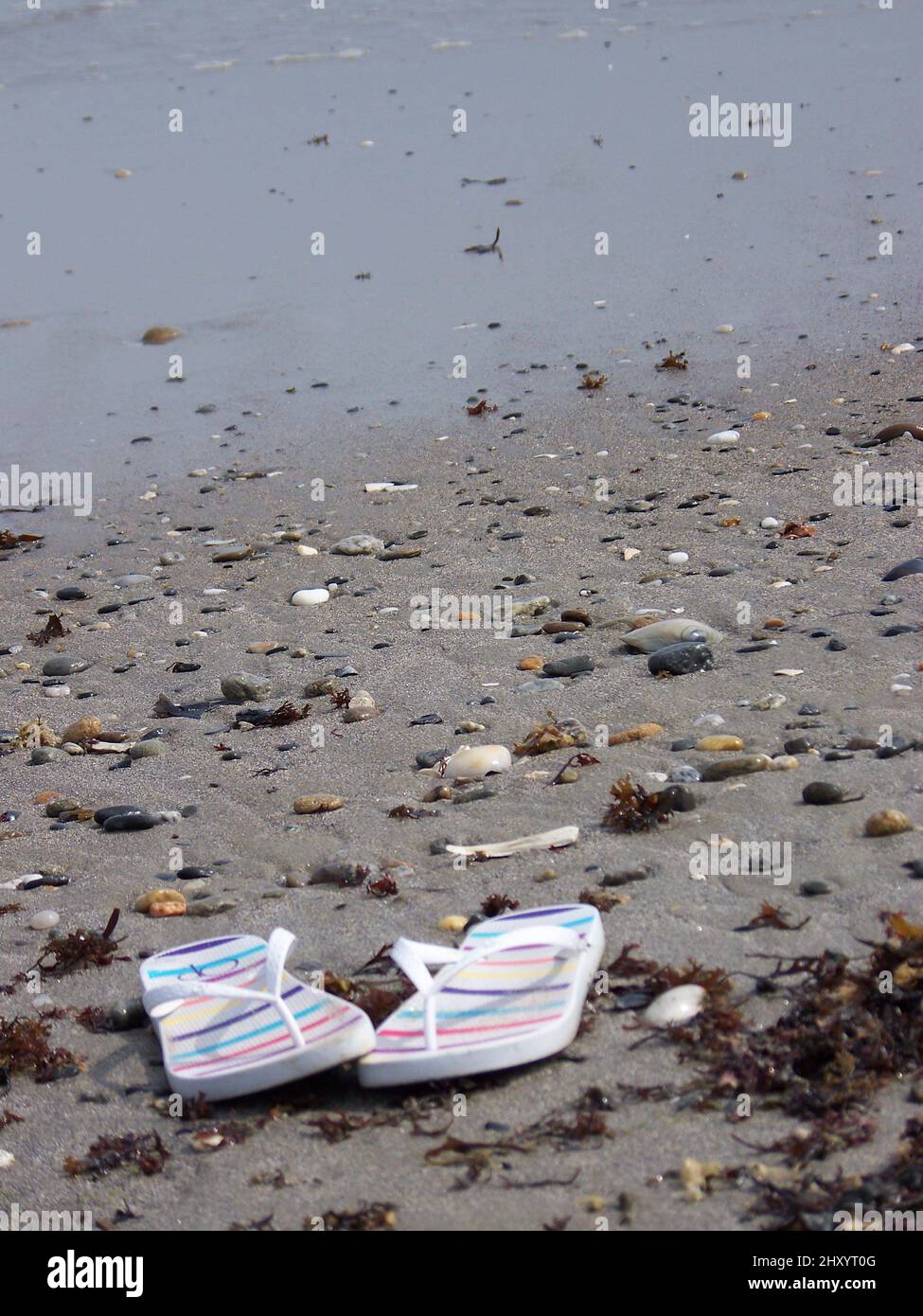 Vertical shot of flip flops on a pebbled beach in Narragansett ...