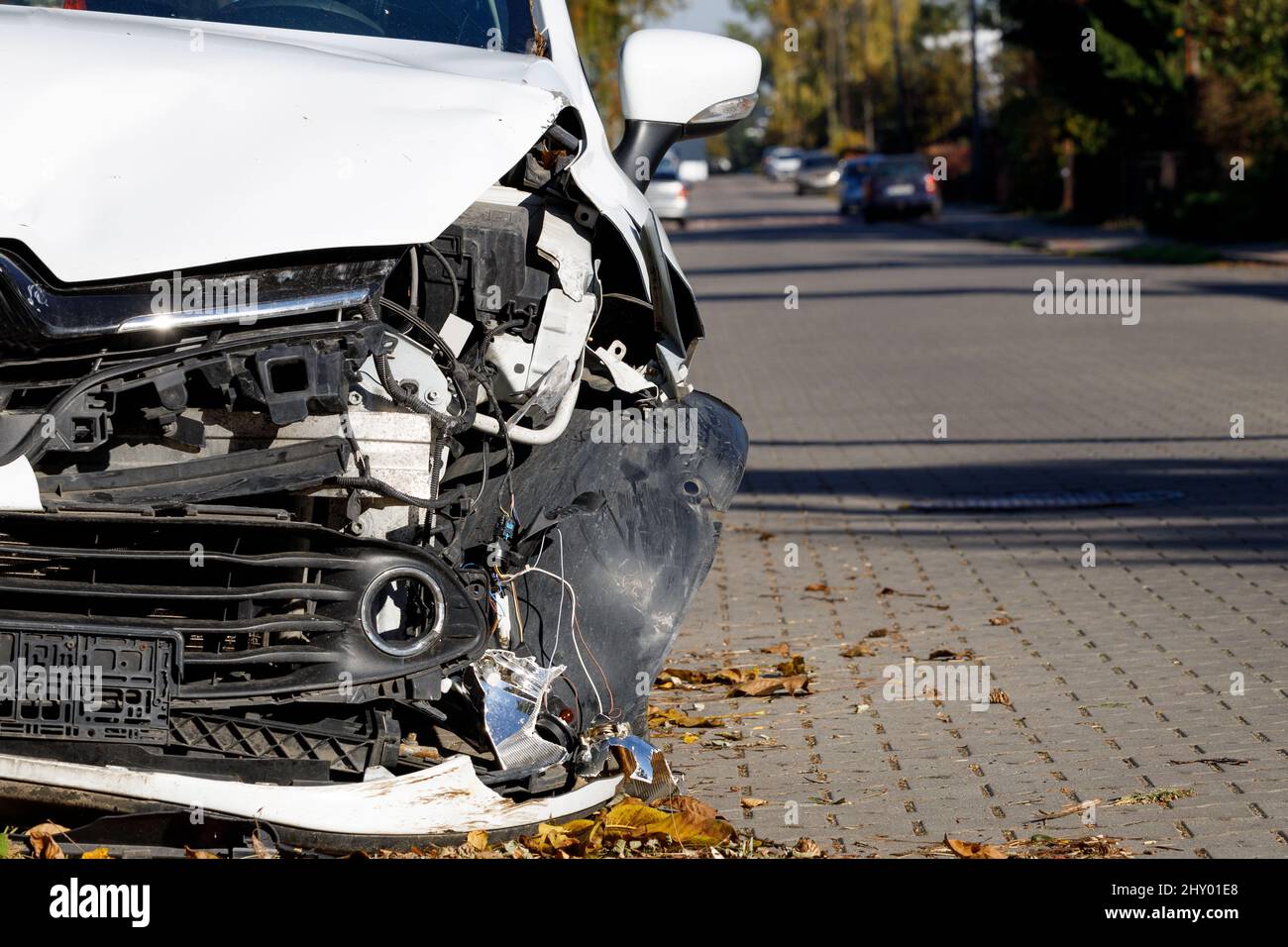 Closeup of the front side of a crashed car on a road under a bright ...