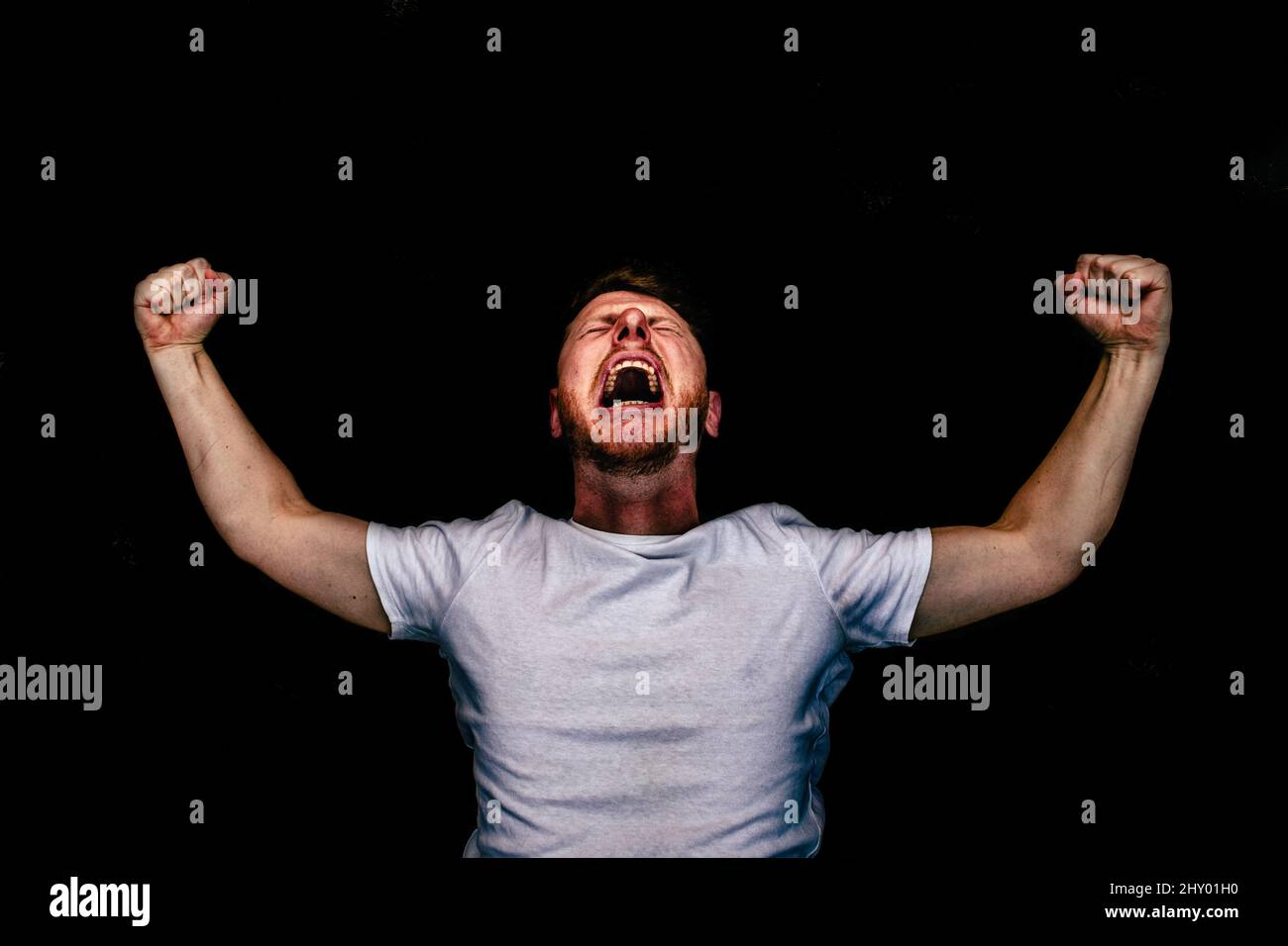Young caucasian man crying from anger on isolated black background with ...