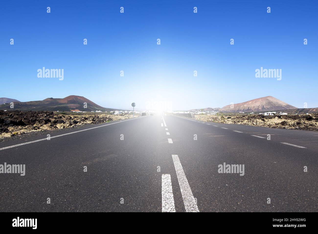 Wide highway going through the rural fields and the bright sunlight ...
