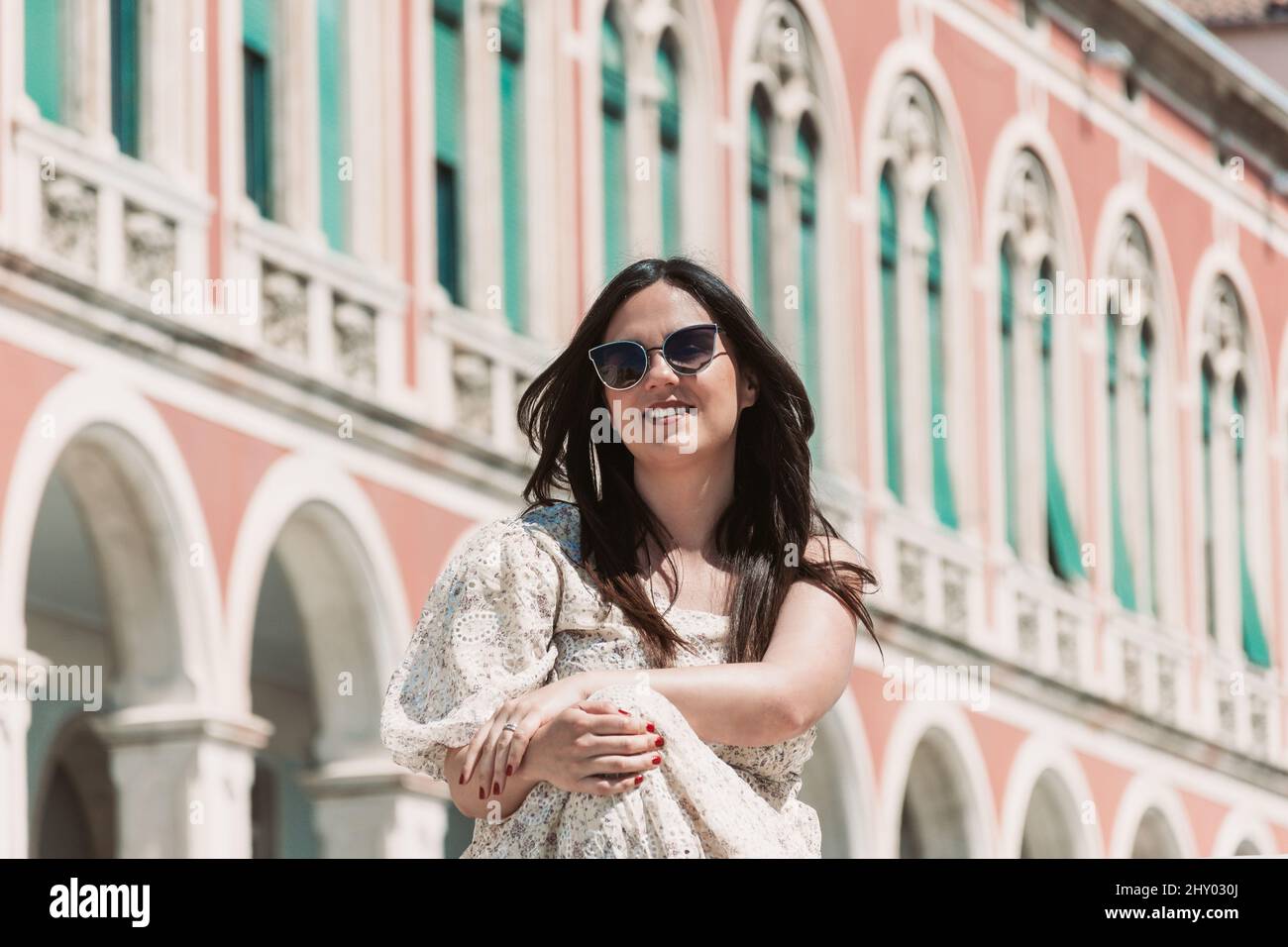Portrait of beautiful young woman with long dark hair, sitting in ...